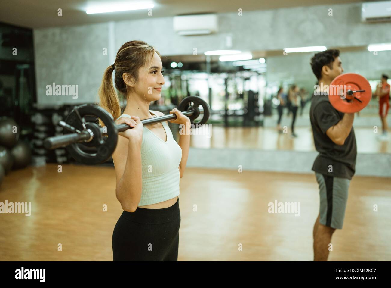 attractive asian woman lifting barbell during group exercise Stock ...