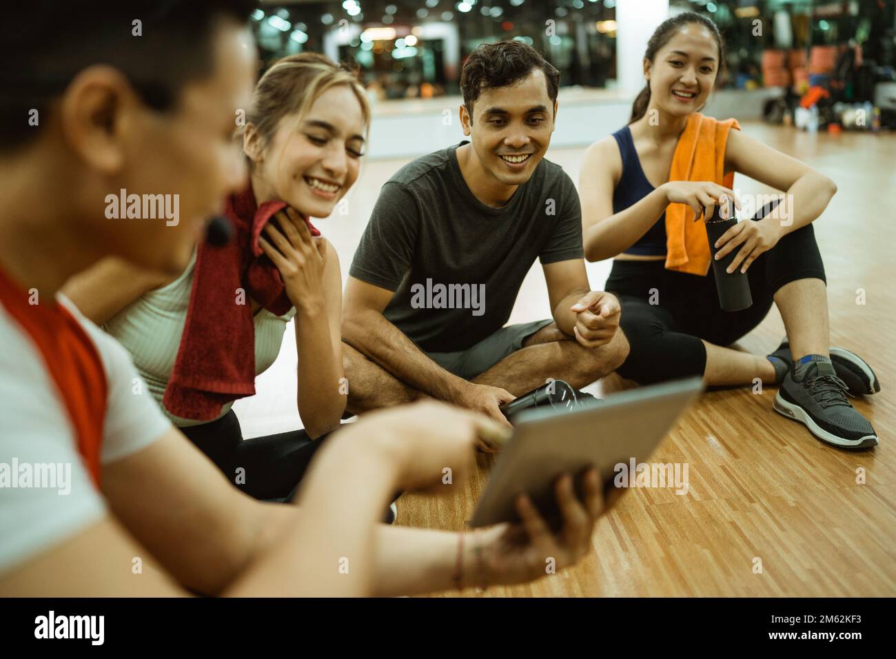 male instructor showing his pad screen to athletic young people Stock ...