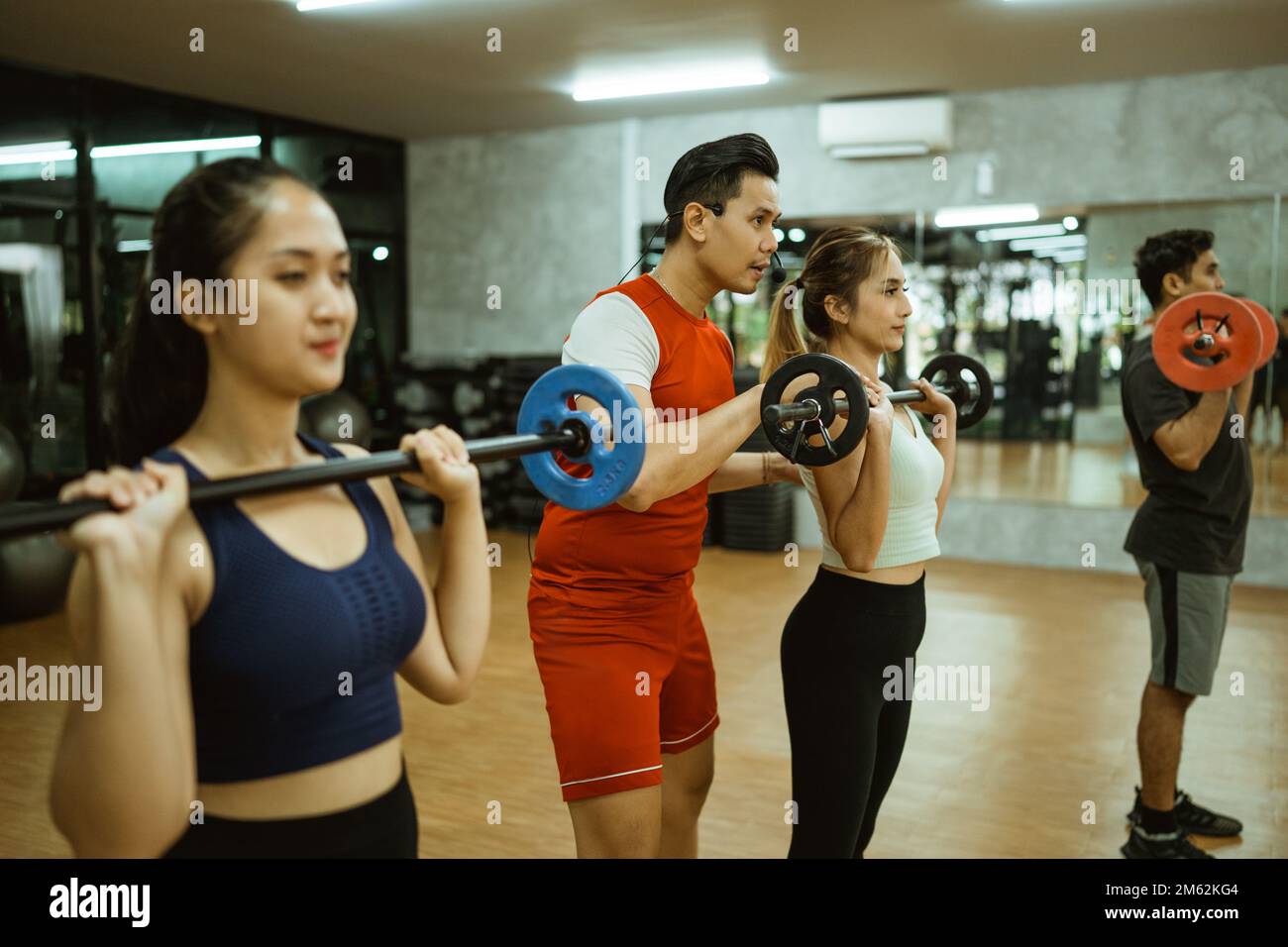 male instructor instructs young woman on proper spinal positioning ...
