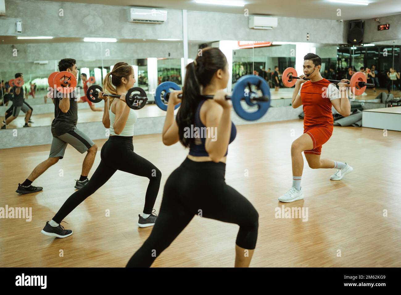 the male instructor set an example doing barbell back squats Stock ...