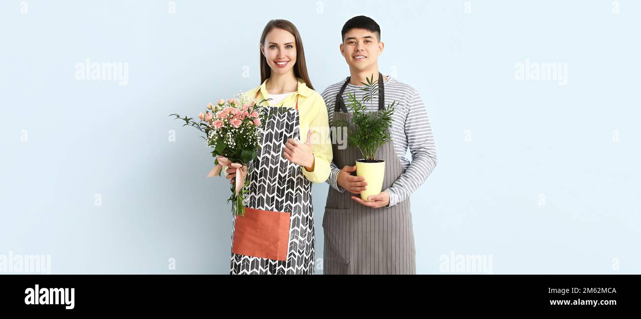Portrait of florists with plant and bouquet on light background Stock ...