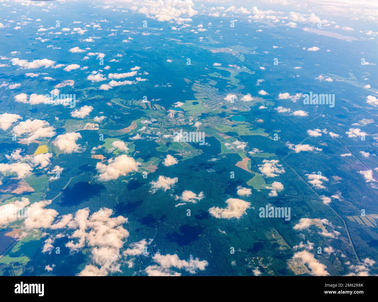 Aerial view from airplane window above green ground. View from the ...