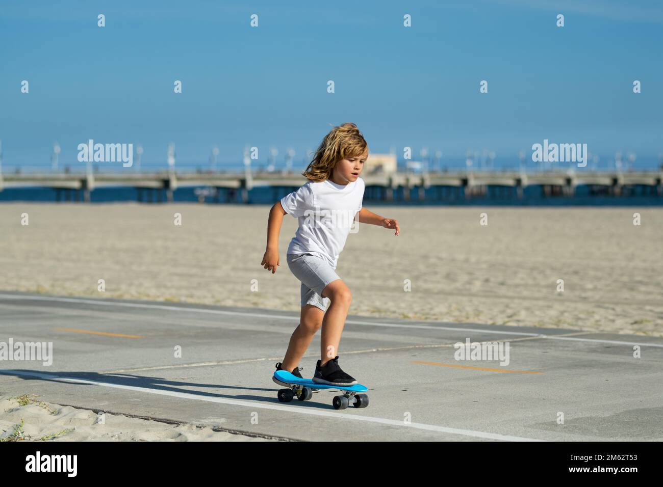 Young boy on his skateboard striking and practices his skill at the ...