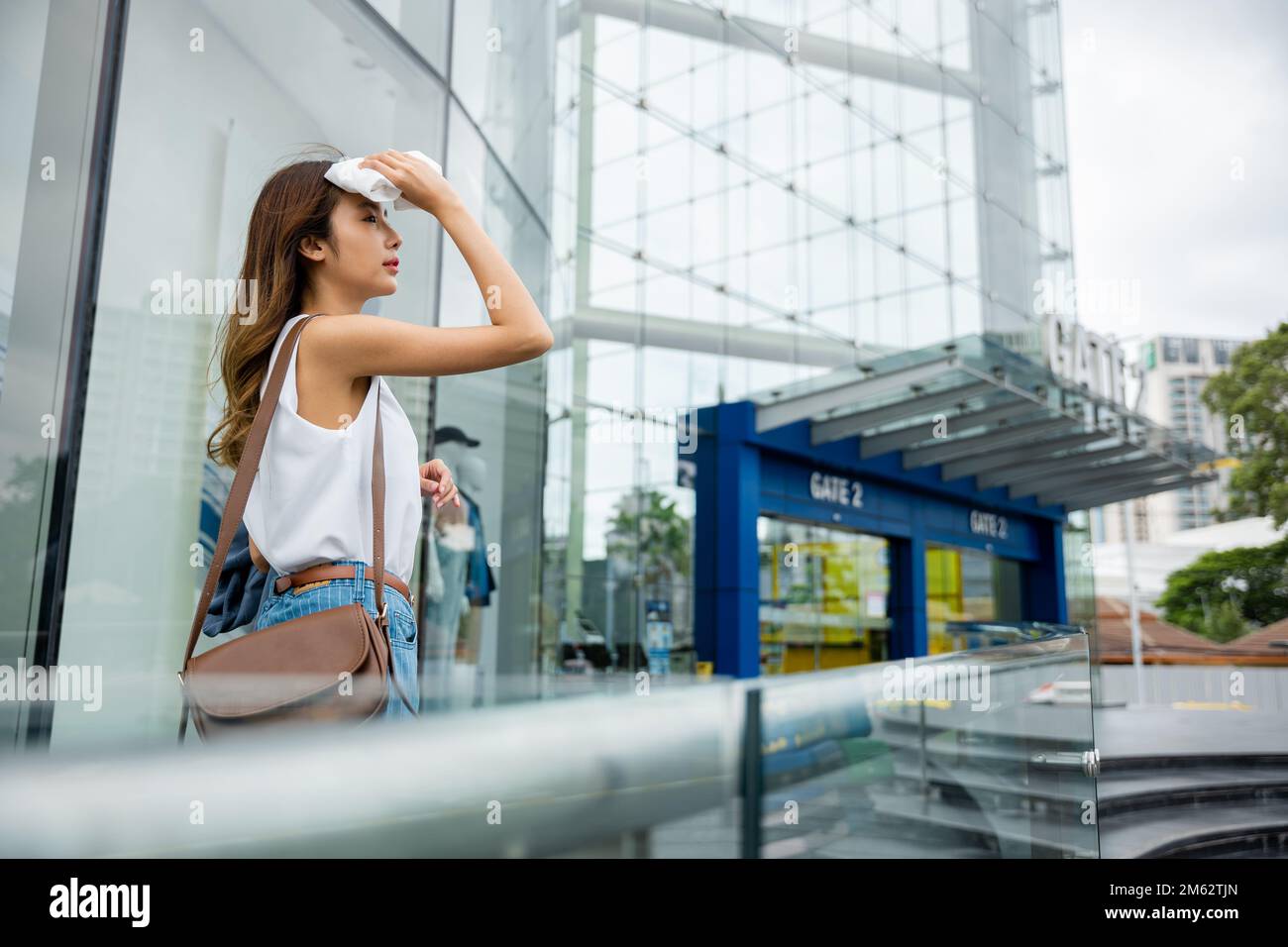 Asian beautiful business woman drying sweat her face with cloth in warm ...