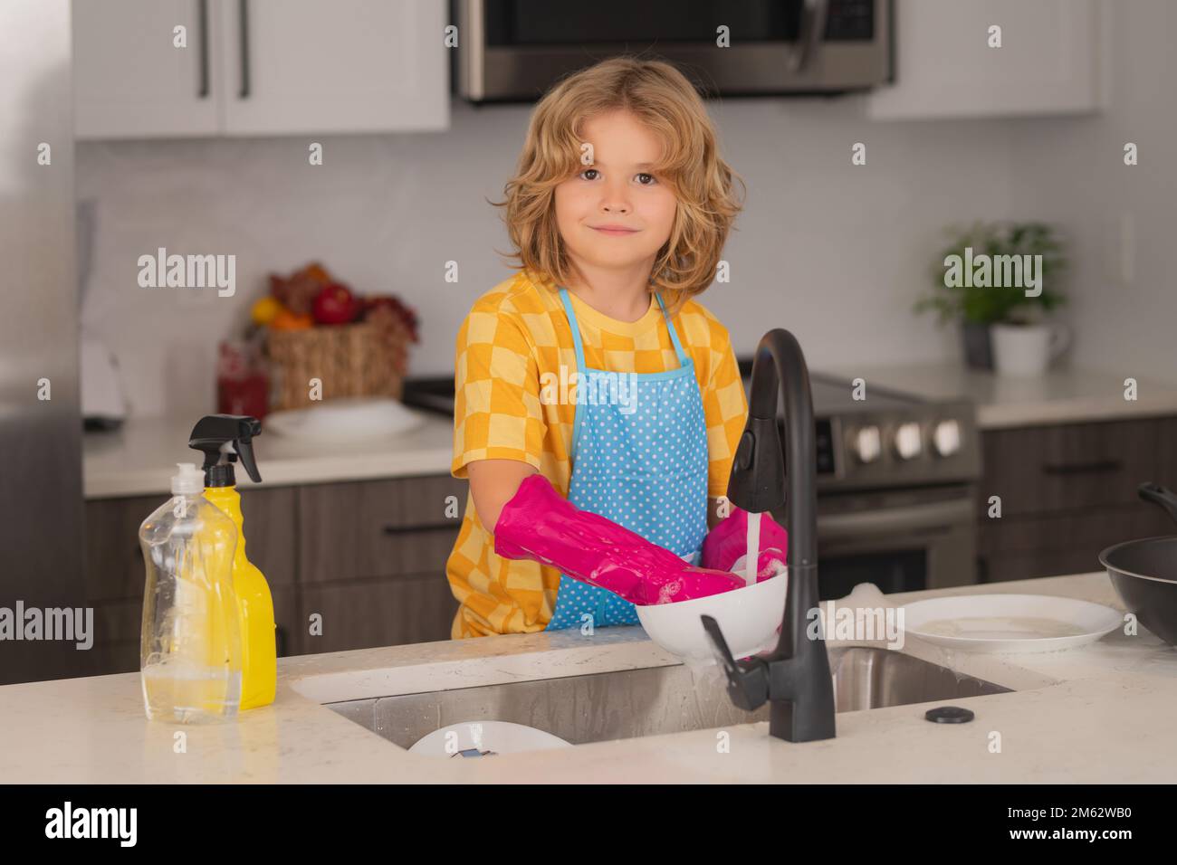 Dish washing concept. Cute child helping with household, wiping dishes ...