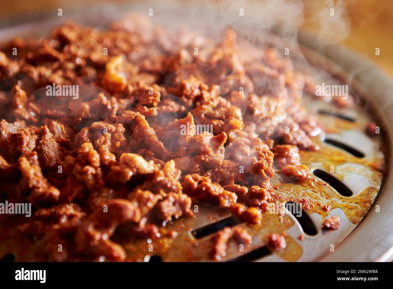 Stir-fried spicy meat on iron plate Stock Photo - Alamy