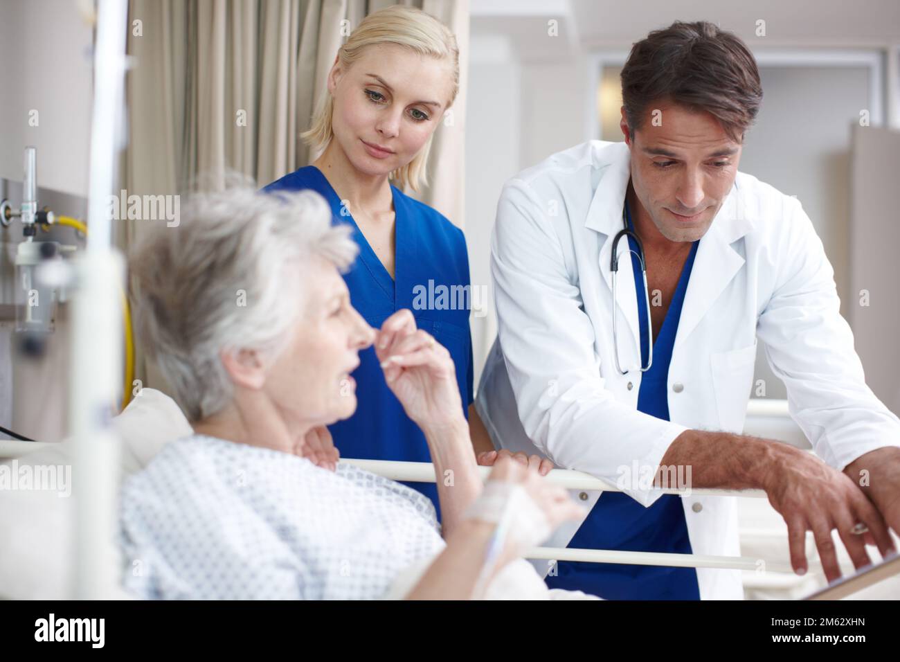 Recovering well. A doctor and his young nurse talking with their ...