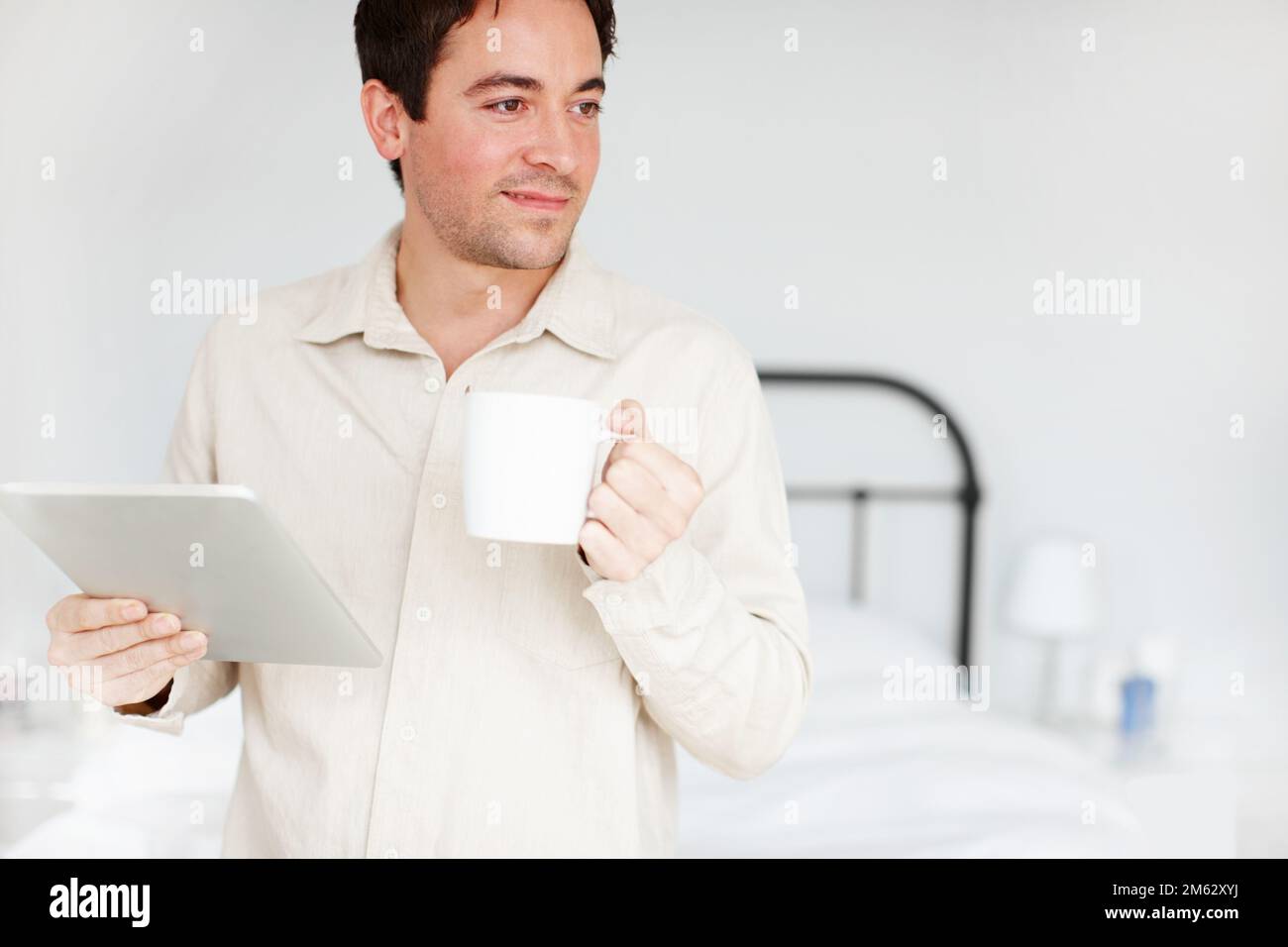 Enjoying modern technology in the morning. A handsome young man ...