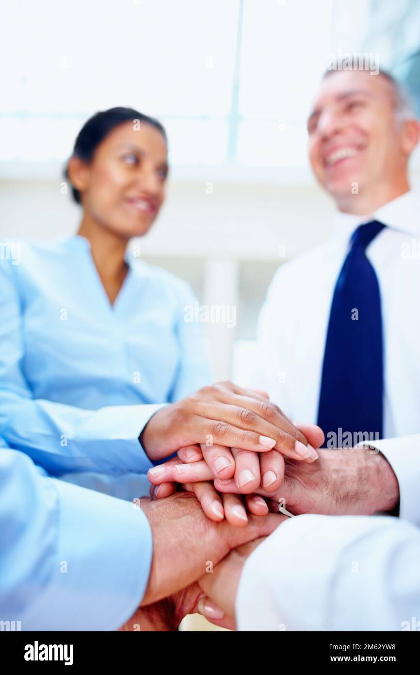 Happy working together. Smiling executives with hands on top of one ...