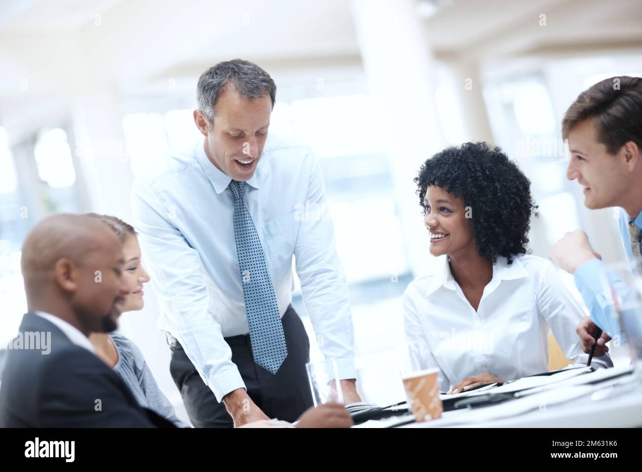 Whats on the meeting agenda. A boss talking to his diverse group of ...