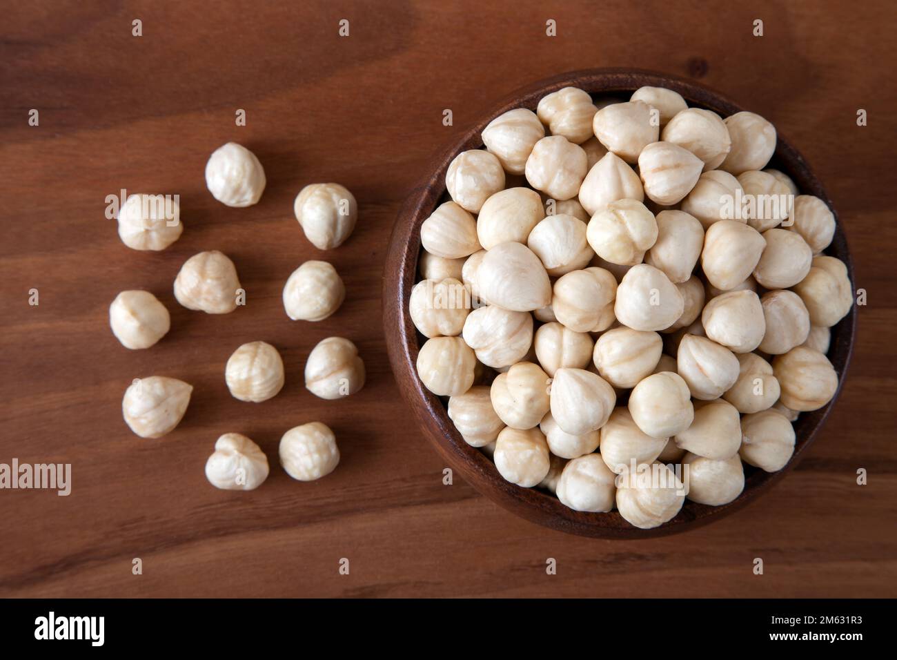 Top view of a bowl full of peeled hazelnuts on wooden table Stock Photo ...