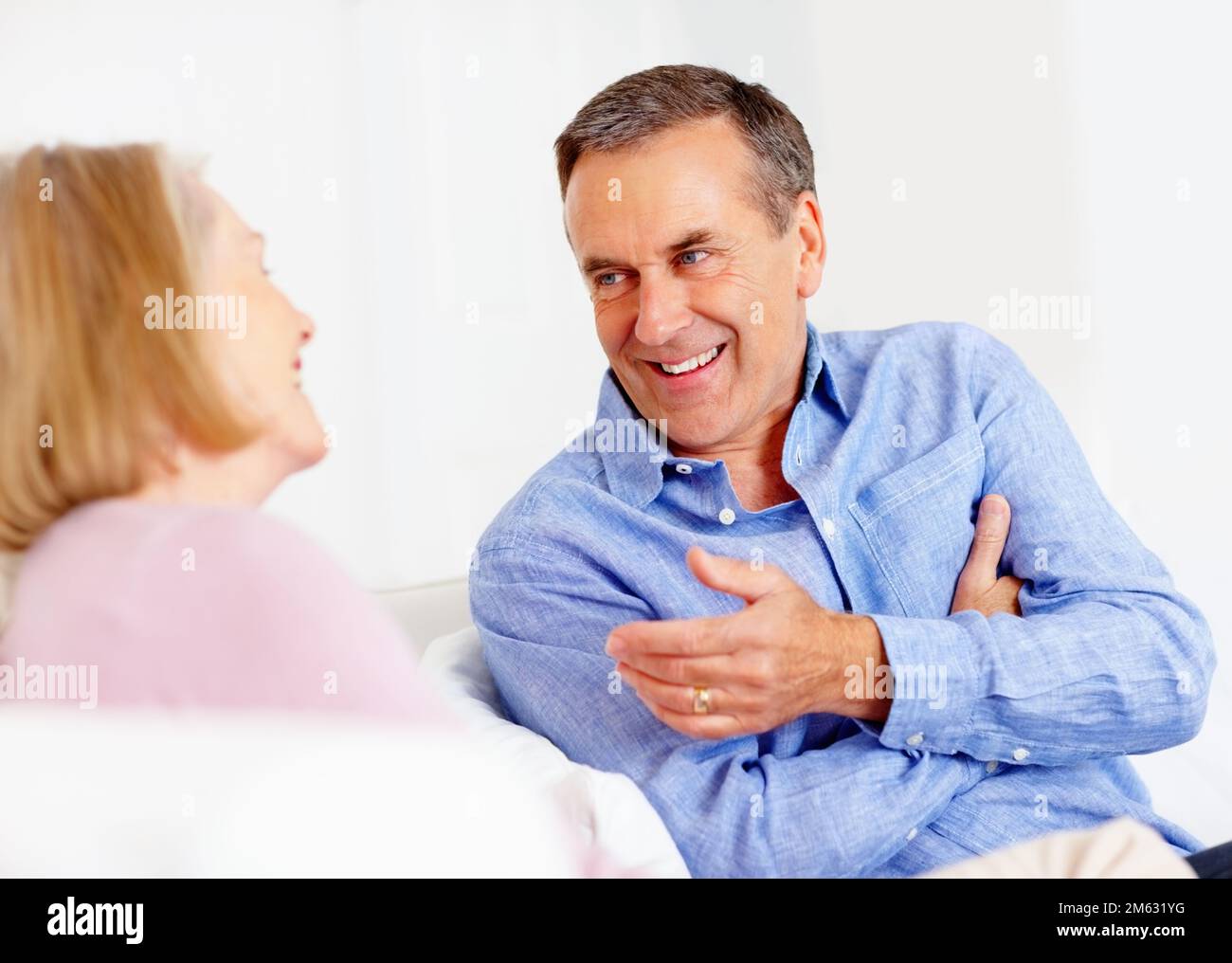 Smiling senior man discussing with wife at home. Portrait of a smiling ...