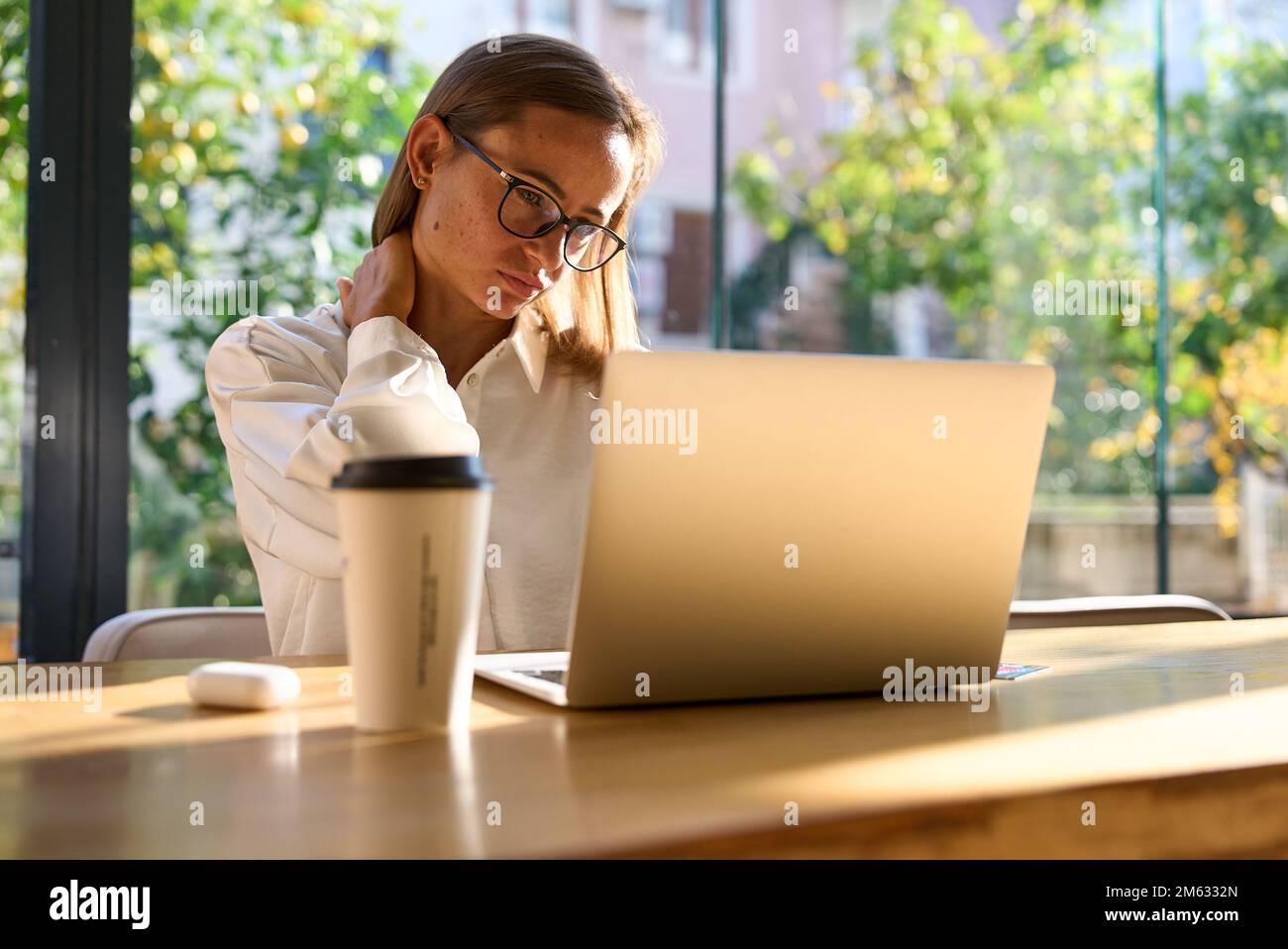 Exhausted businesswoman stretching with arms raised while working in ...