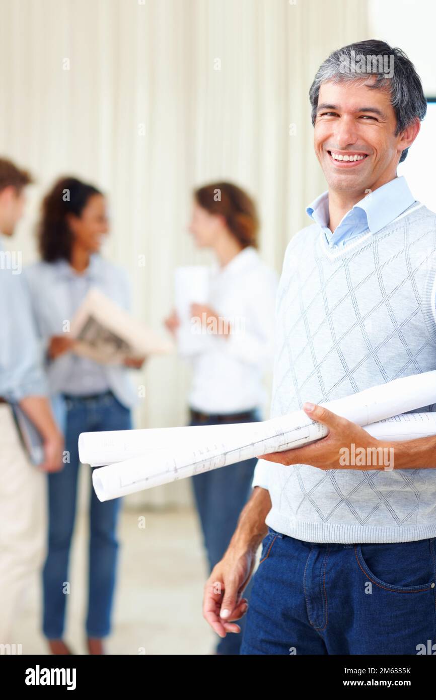 Male architect holding blueprint. Mature male architect holding ...