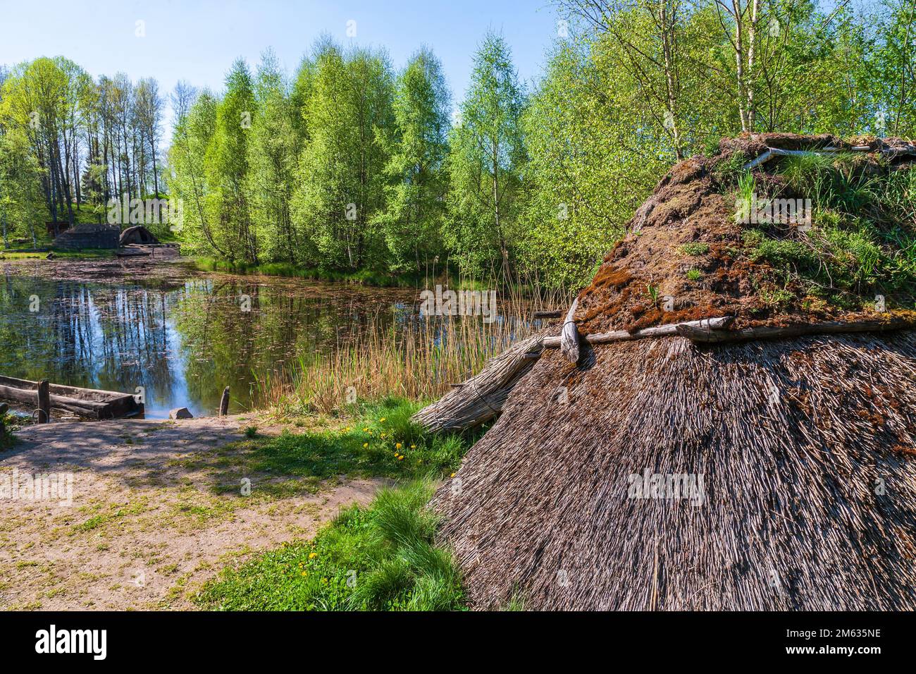 Grass hut of reeds by a lake Stock Photo - Alamy