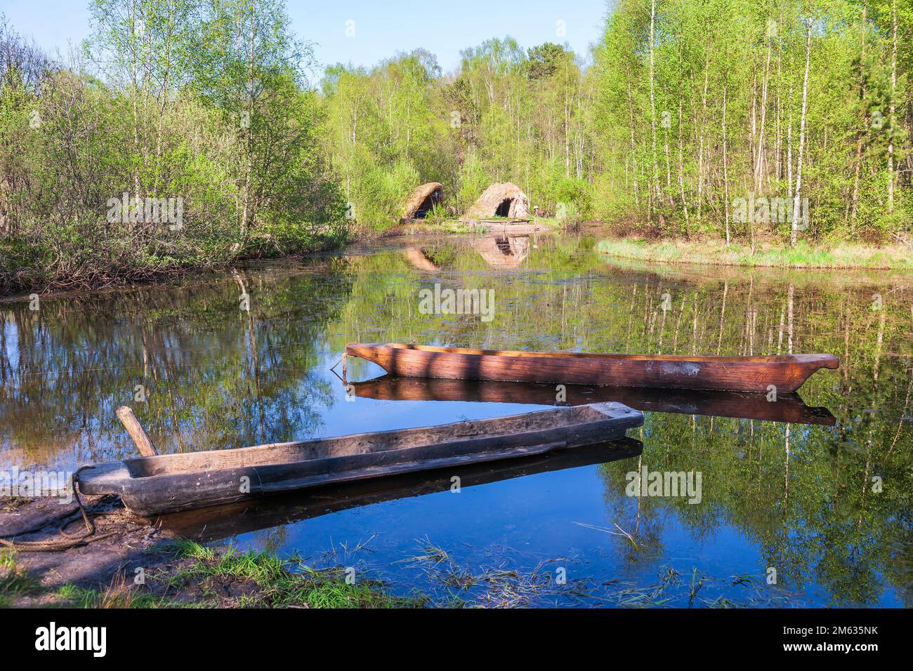 Log boats in a lake with some grass hut on the beach Stock Photo - Alamy