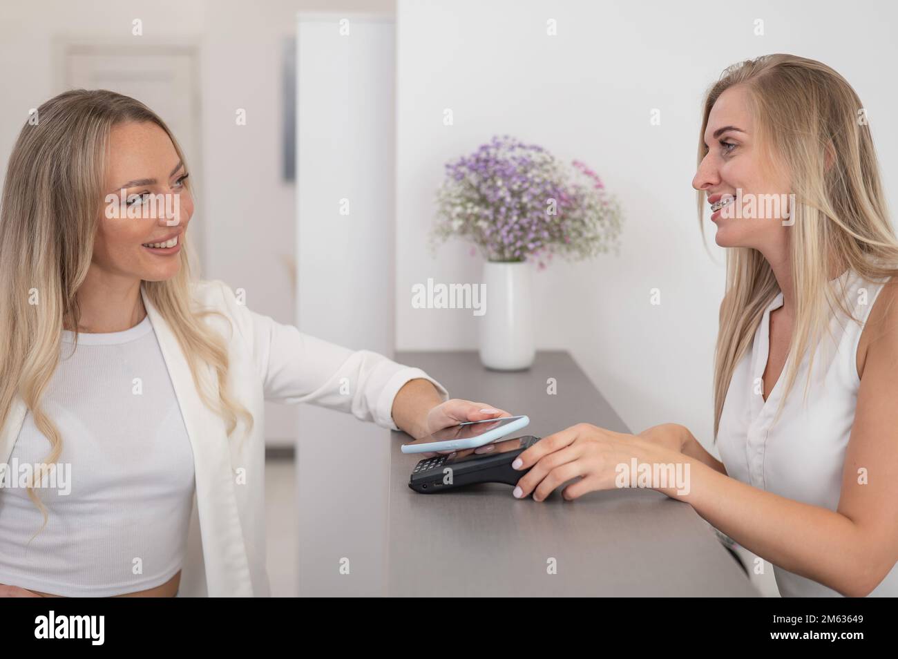A woman pays using a non -contact payment of the NFC used by a ...