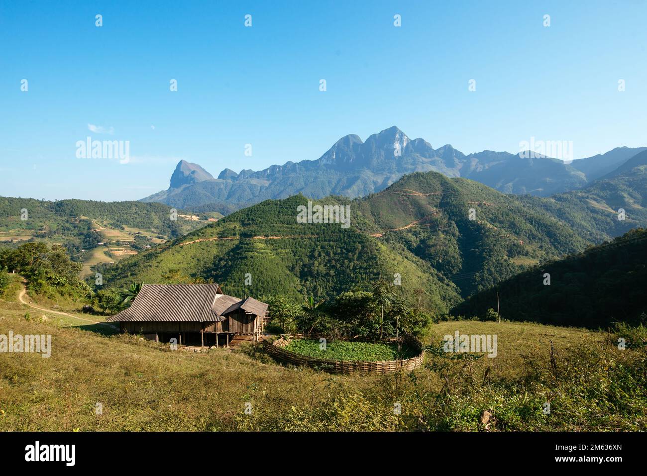 Picturesque scenery of small wooden house surrounded by green hills and ...