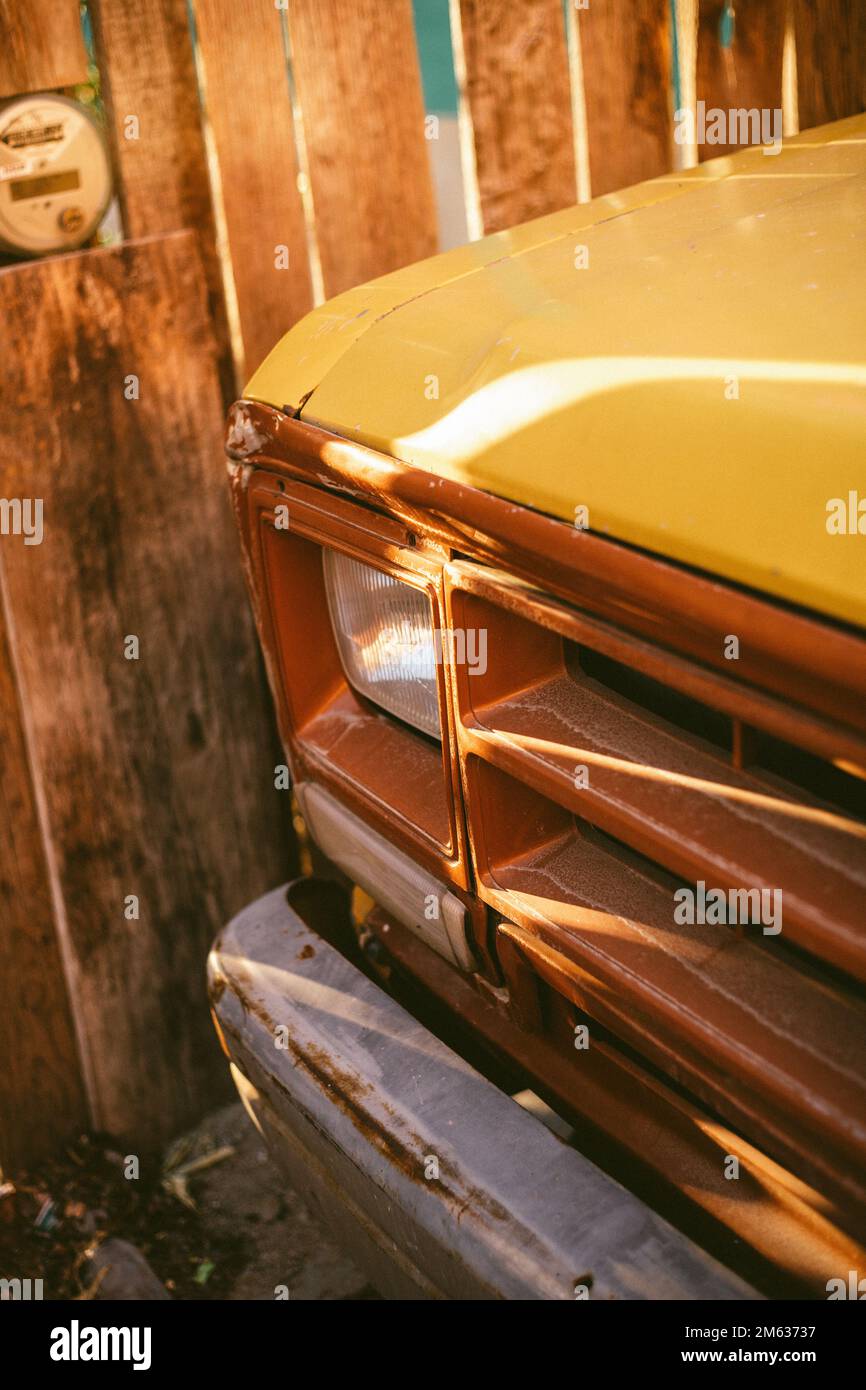 High angle of old shabby yellow retro car with square shaped headlight ...