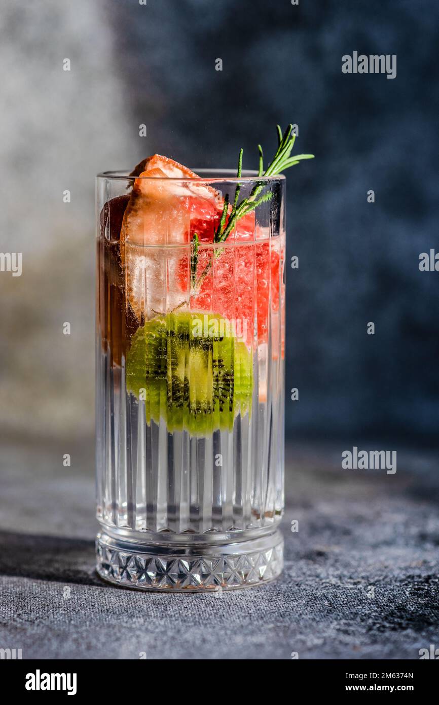 Summer tropical cocktail of vodka and sprite with ripe fruits and ...