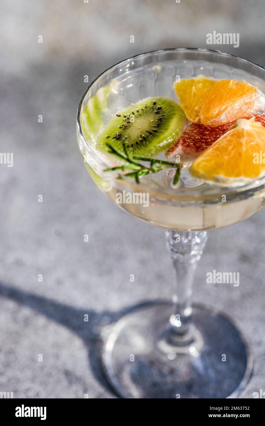 Summer tropical cocktail of vodka and sprite with ripe fruits and ...
