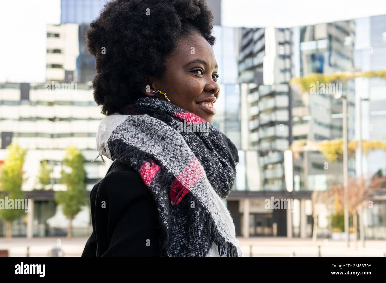Side view of cheerful young African American woman with Afro hairstyle ...
