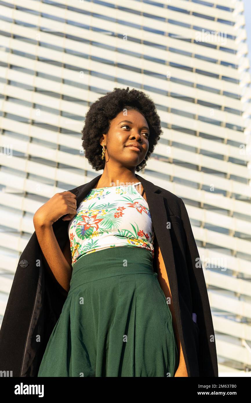 Low angle of positive young African American female in black jacket ...