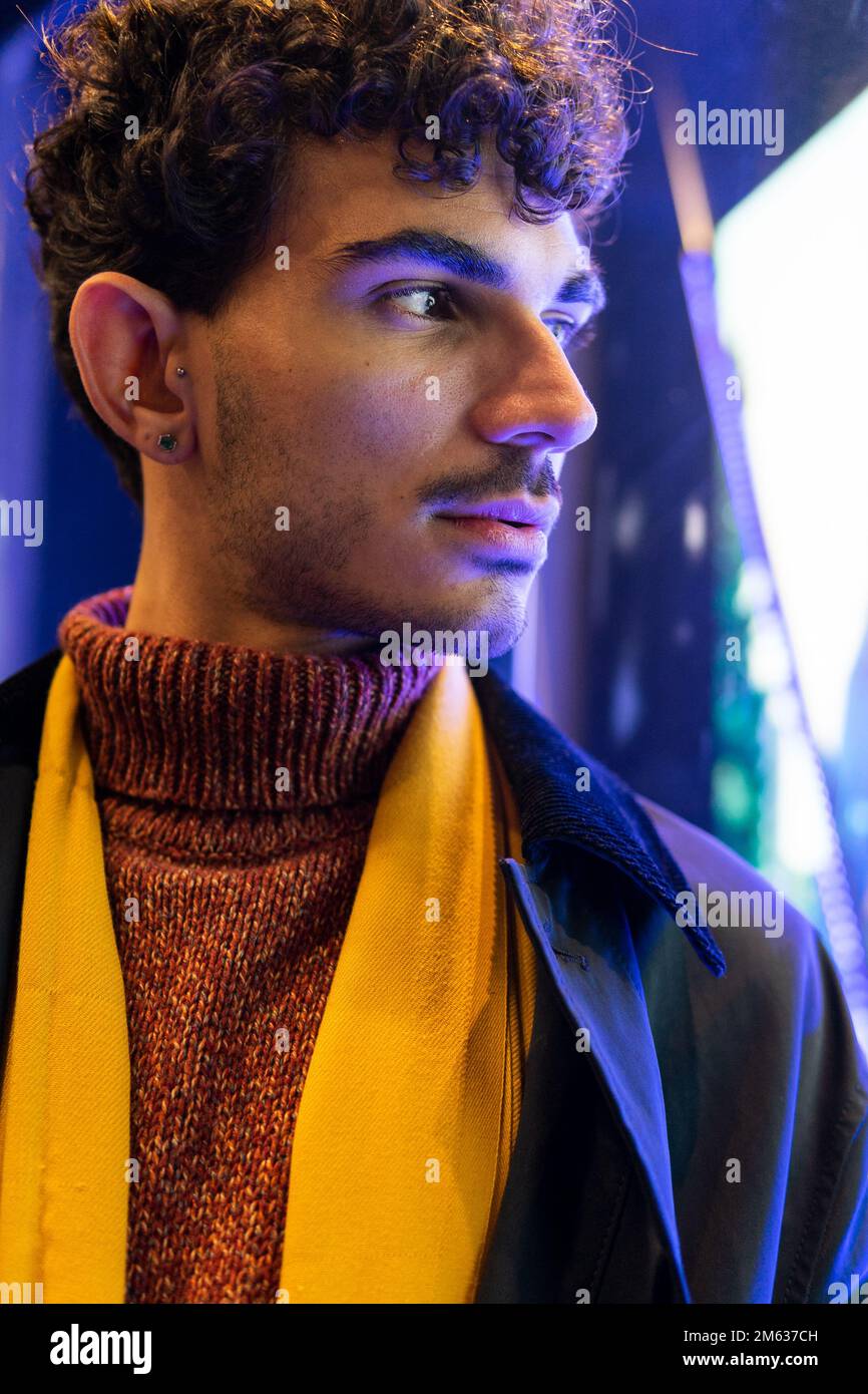 Pondering ethnic guy with curly hair looking out window Stock Photo - Alamy