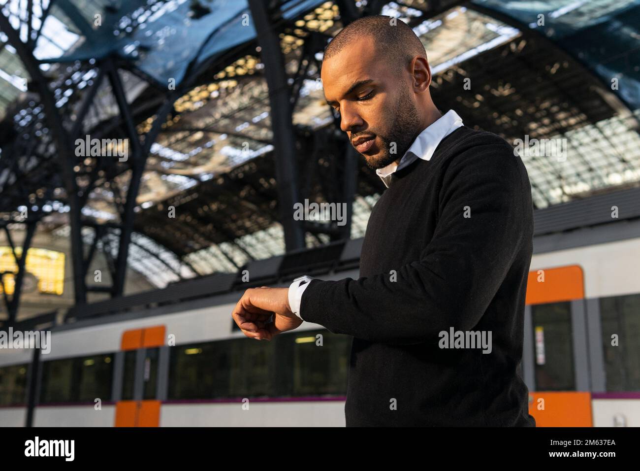From below side view of punctual ethnic man in smart casual clothes ...