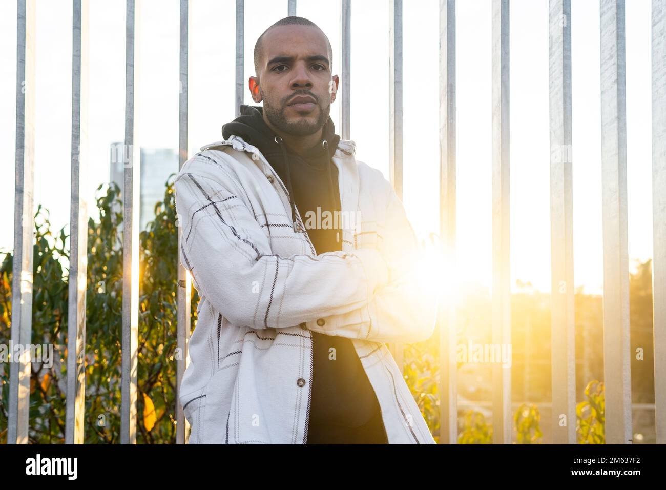Serious African American male in casual clothes standing with crossed ...