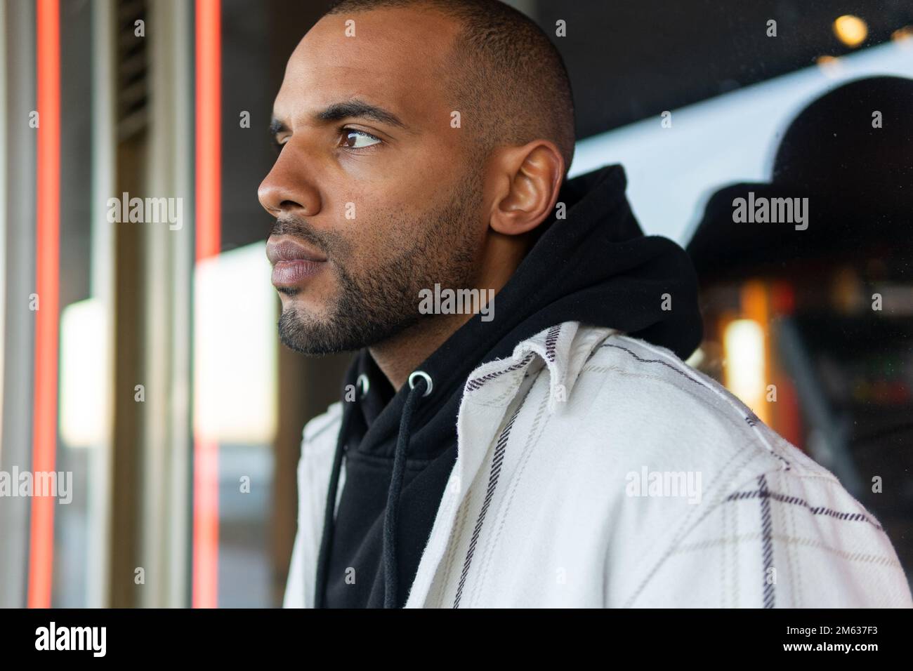Side view of bearded African American male in black hoodie standing ...