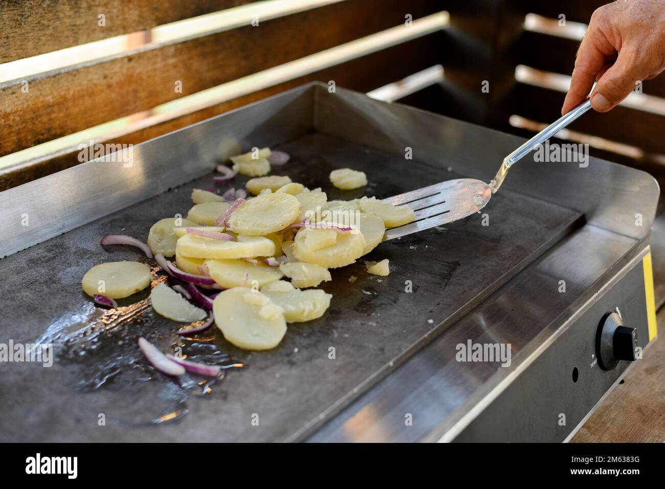 High angle of crop anonymous chef with spatula preparing appetizing ...