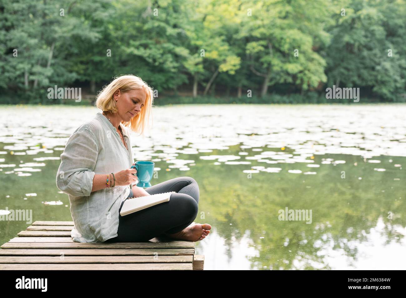 Side view full body of woman in casual outfit sitting with crossed legs ...