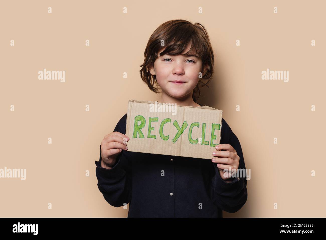 Girl in black outerwear holding Recycle poster and looking at camera ...