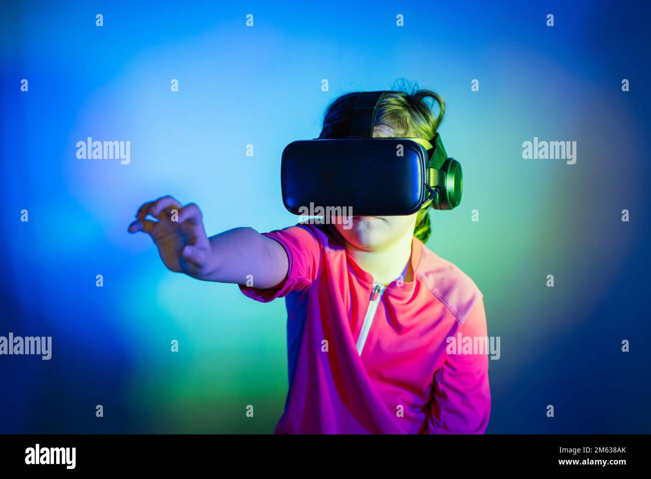 Child in VR goggles interacting with virtual world touching invisible ...