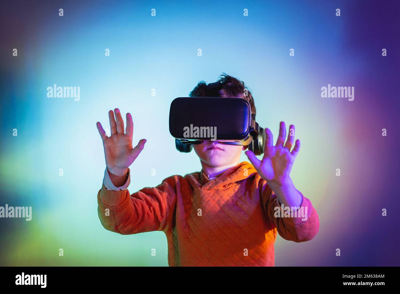 Child in VR goggles interacting with virtual world touching invisible ...
