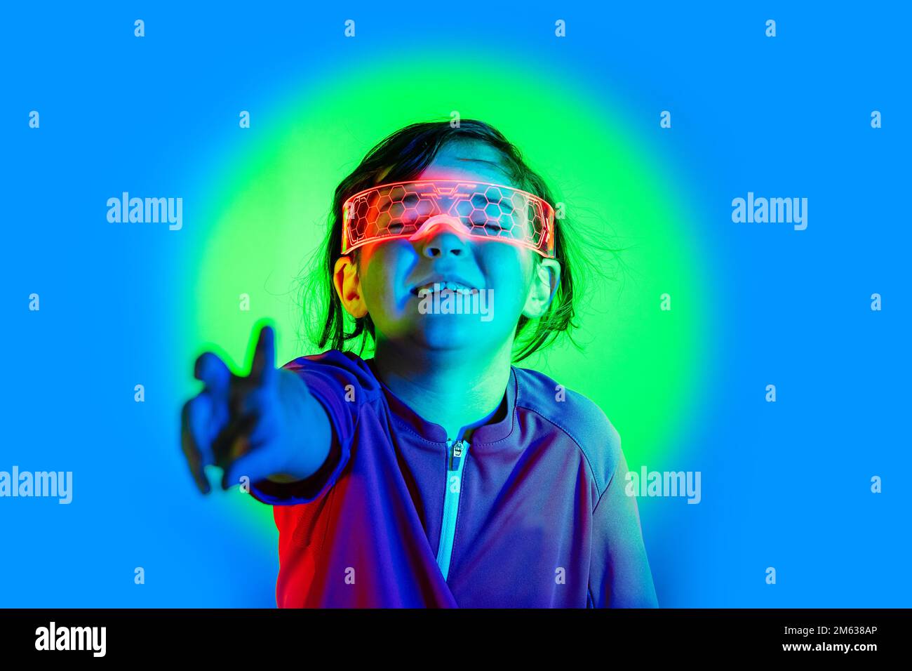 Cheerful kid in VR goggles interacting with virtual reality touching ...