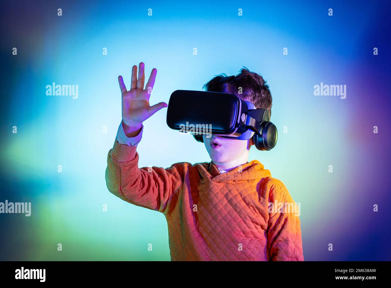 Child in VR goggles interacting with virtual world touching invisible ...