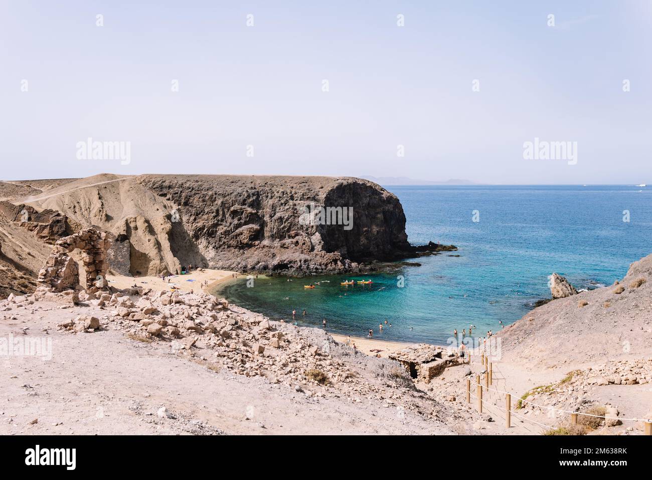 Aerial view of blue sea water with lots of people on cliffside parrot ...