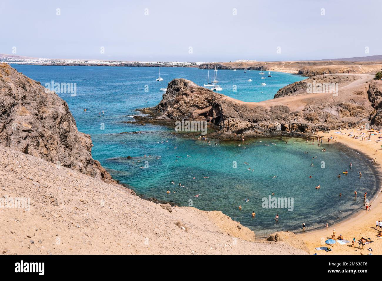 Aerial view of blue sea water with lots of people on cliffside parrot ...