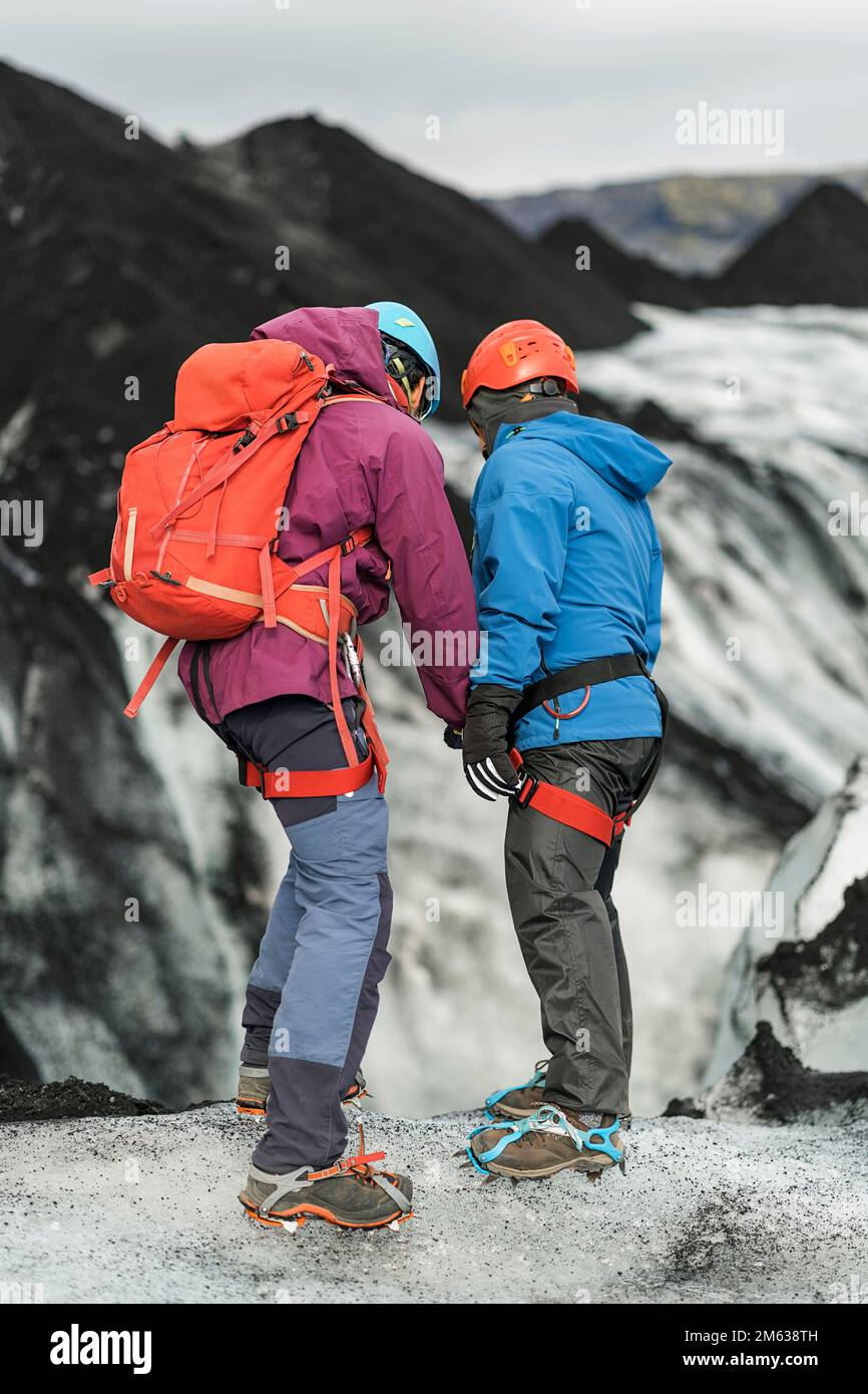 Full body back view of unrecognizable hikers in mountaineering boots ...