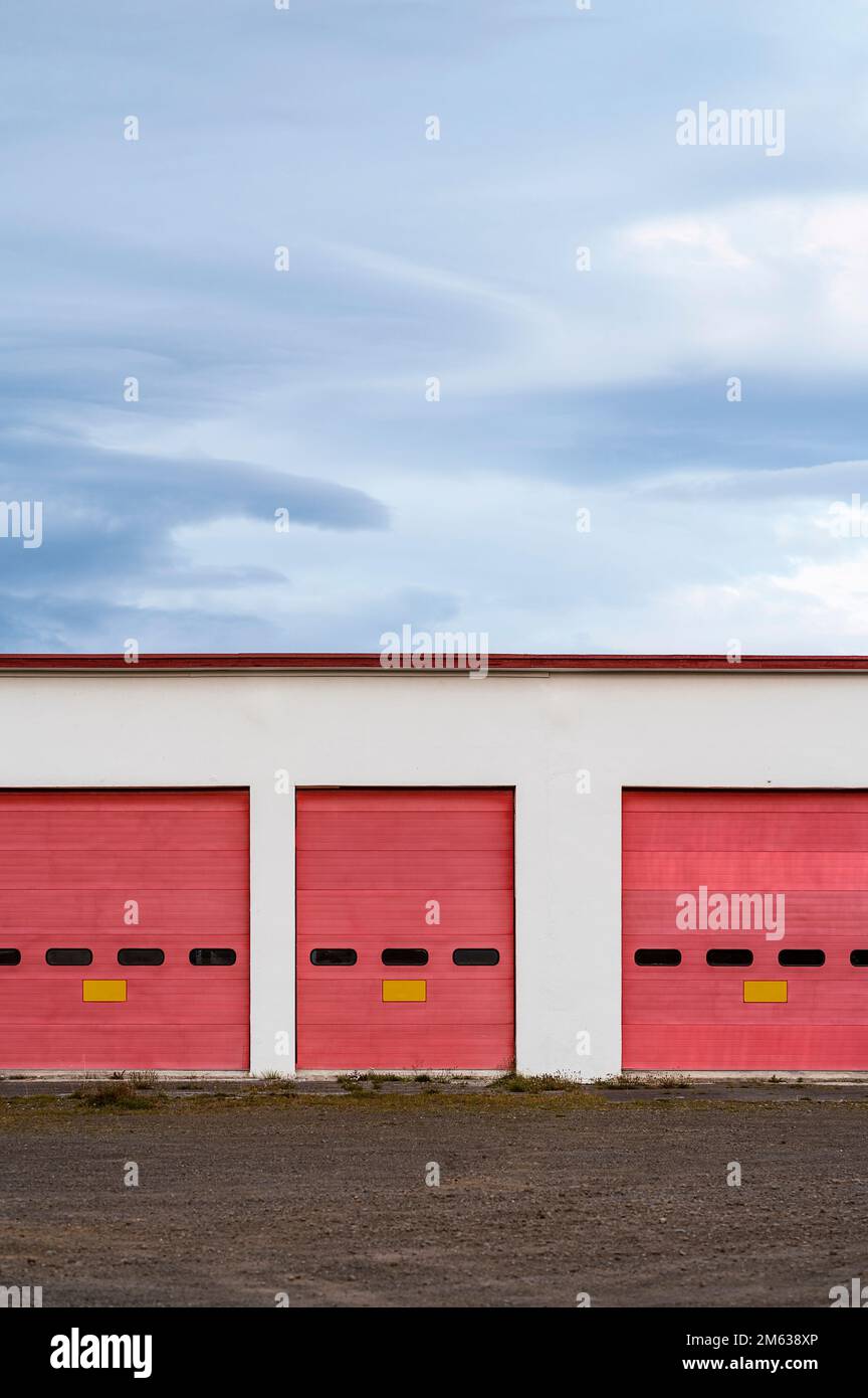 Exterior of modern red storage units under blue cloudy sky located in ...
