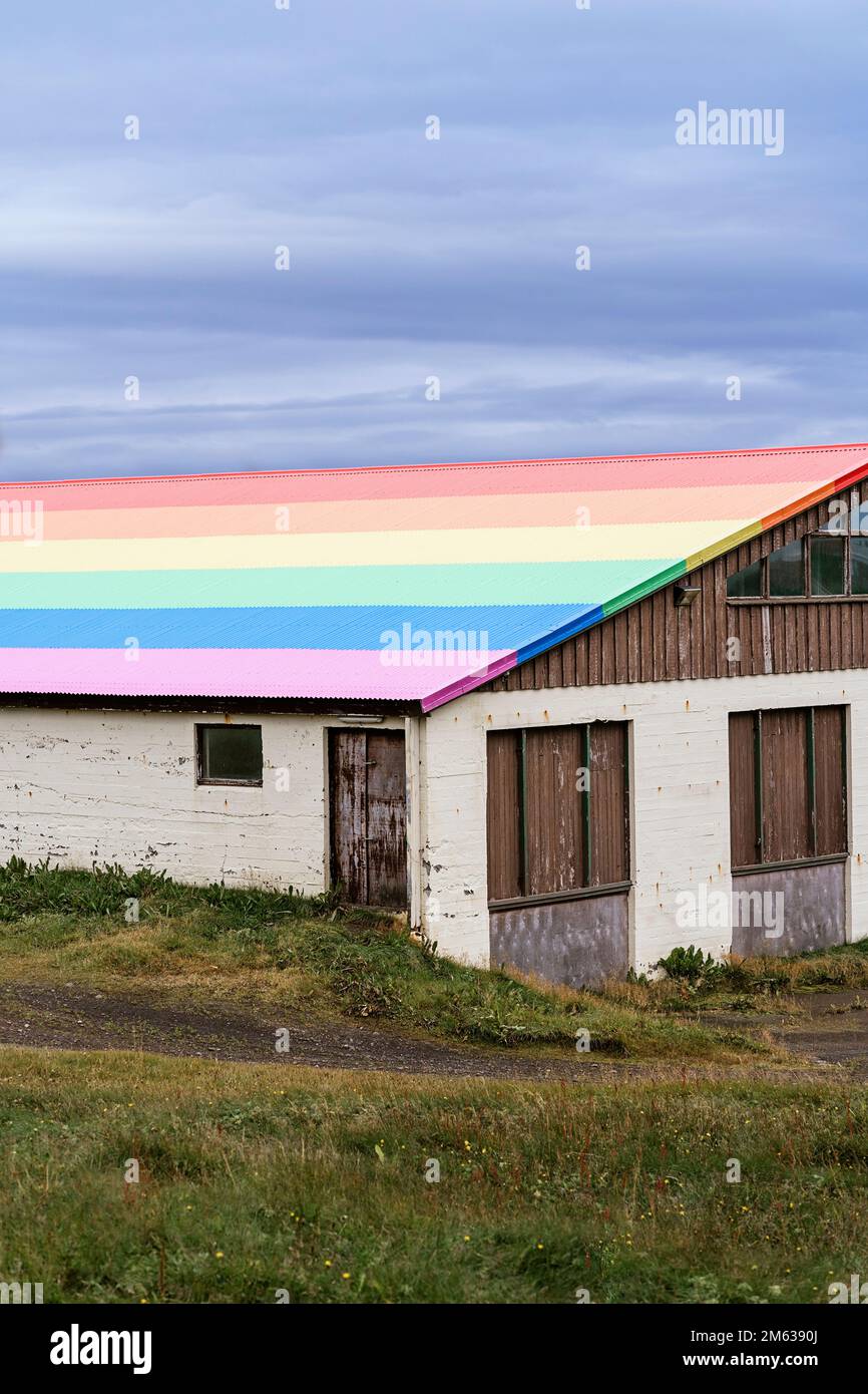 Exterior of shabby rural barn with rainbow colored roof located on ...