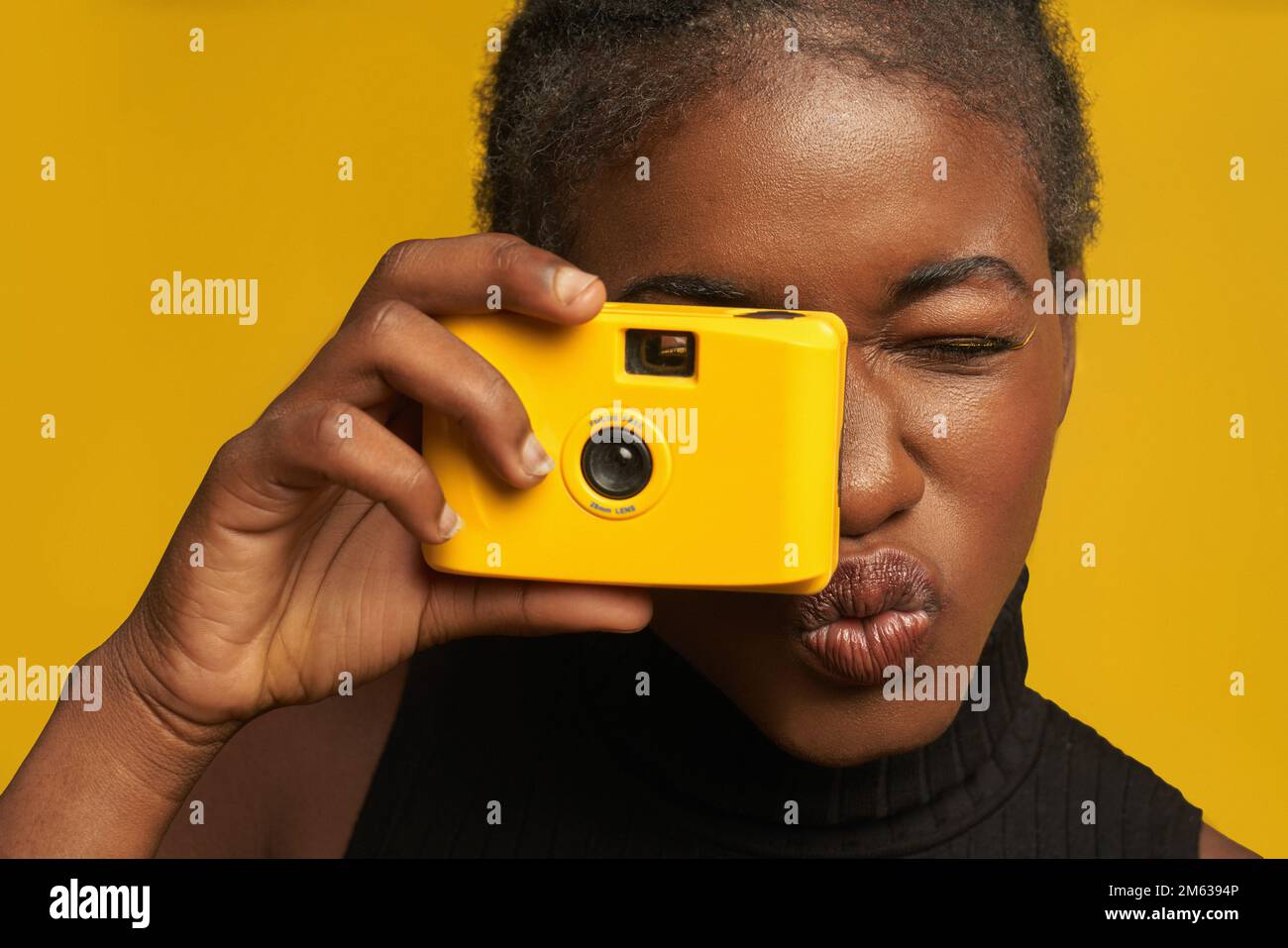 Positive African American female with braided hair in black top taking ...