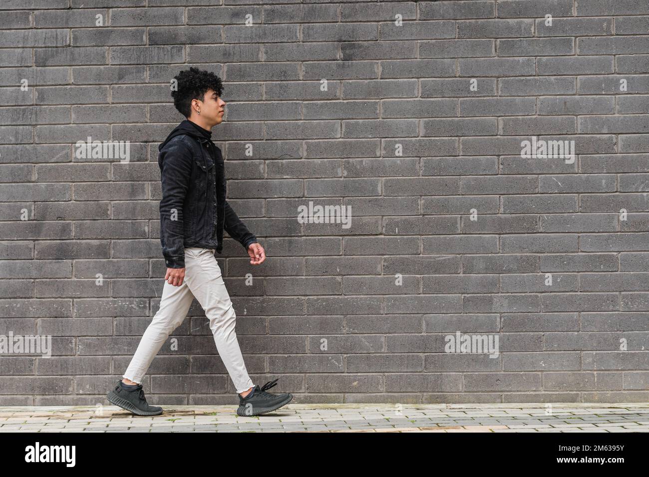 Side view full body of Latin American male in casual outfit walking ...
