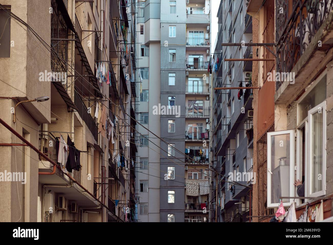 Exterior of high rise building with electric wires and linen drying on ...