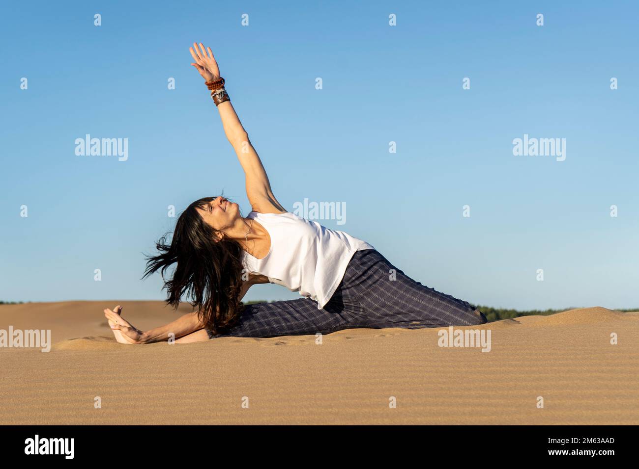 Full body of young woman practicing yoga in Front Splits with Arms Up ...