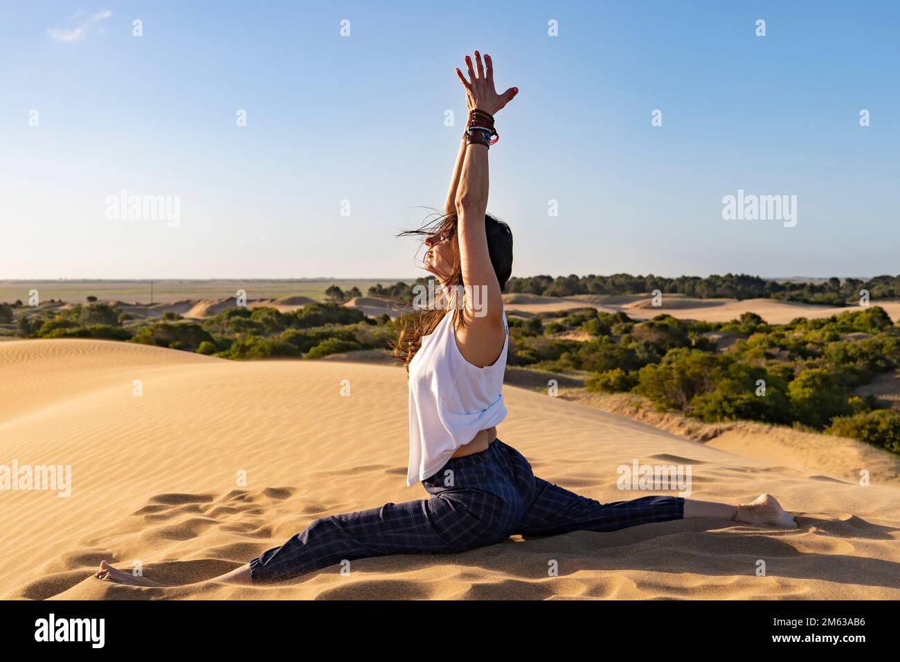 Full body of young woman practicing yoga in Front Splits with Arms Up ...