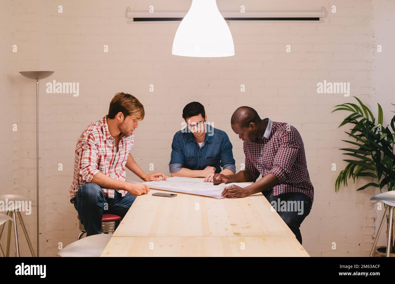 Architects and engineers working at the Office sitting in a large table ...