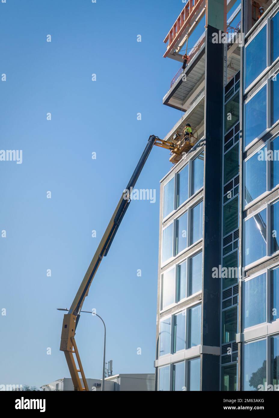 Apartment under construction. Crane lifting building materials and ...